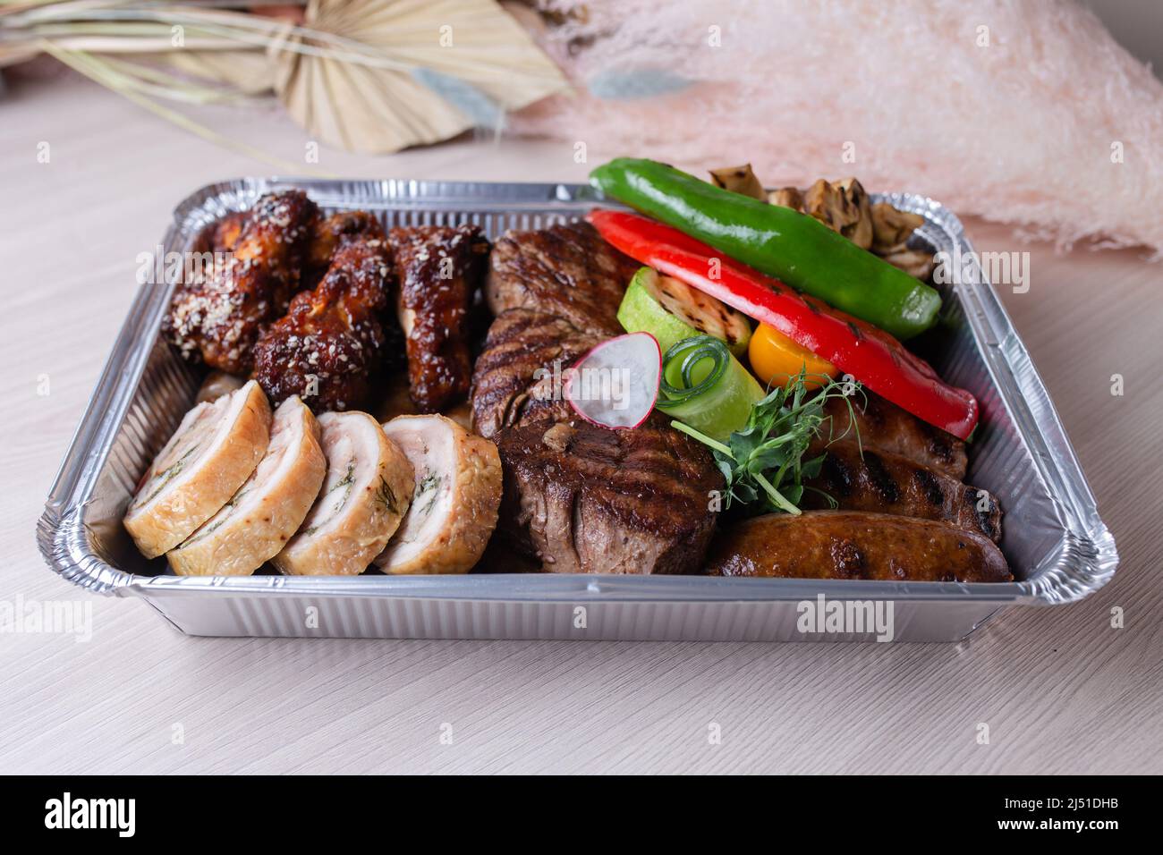 Delivery of healthy restaurant food in a foil box. Grilled meat steak ...