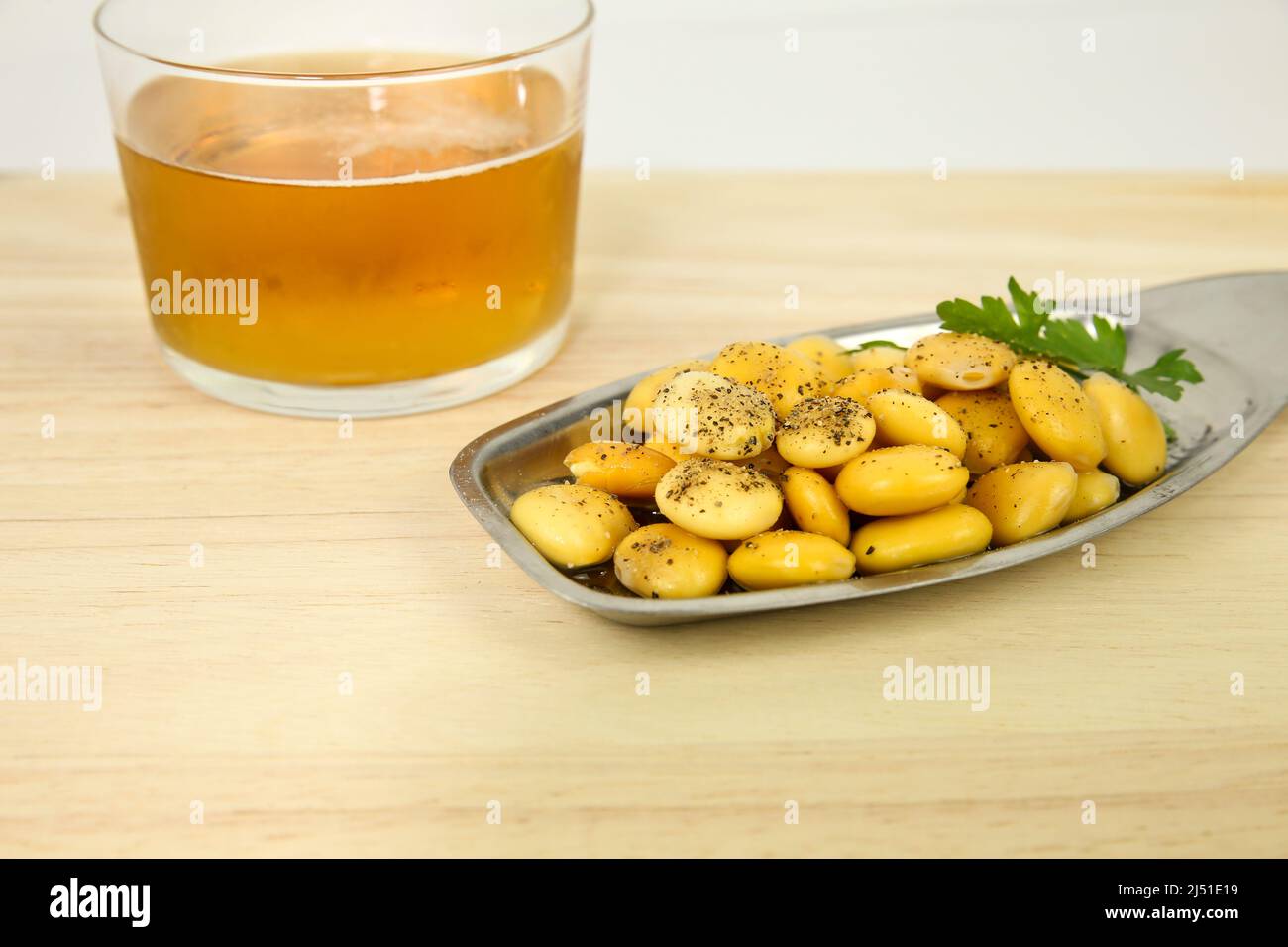 Typical Spanish Tapa of Lupin beans next to cold beer on wooden table ...