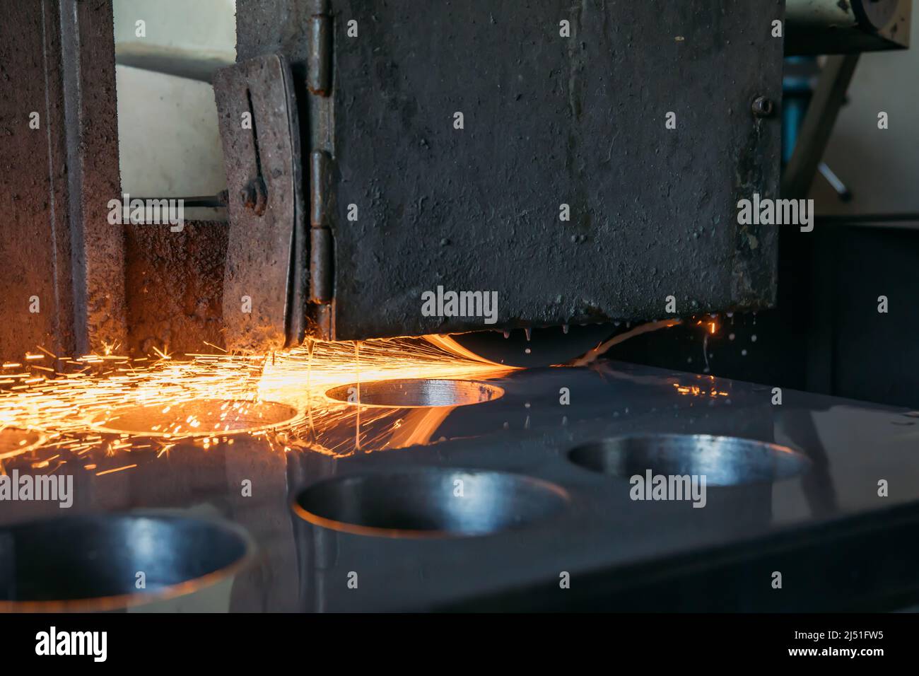 Metalworking industry machine grinder with sparks and fire in a factory ...