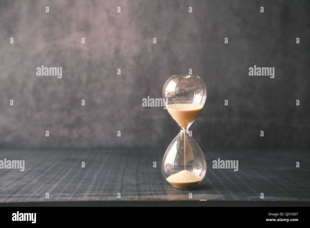 hourglass on table, sand flowing through the bulb of sandglass Stock ...