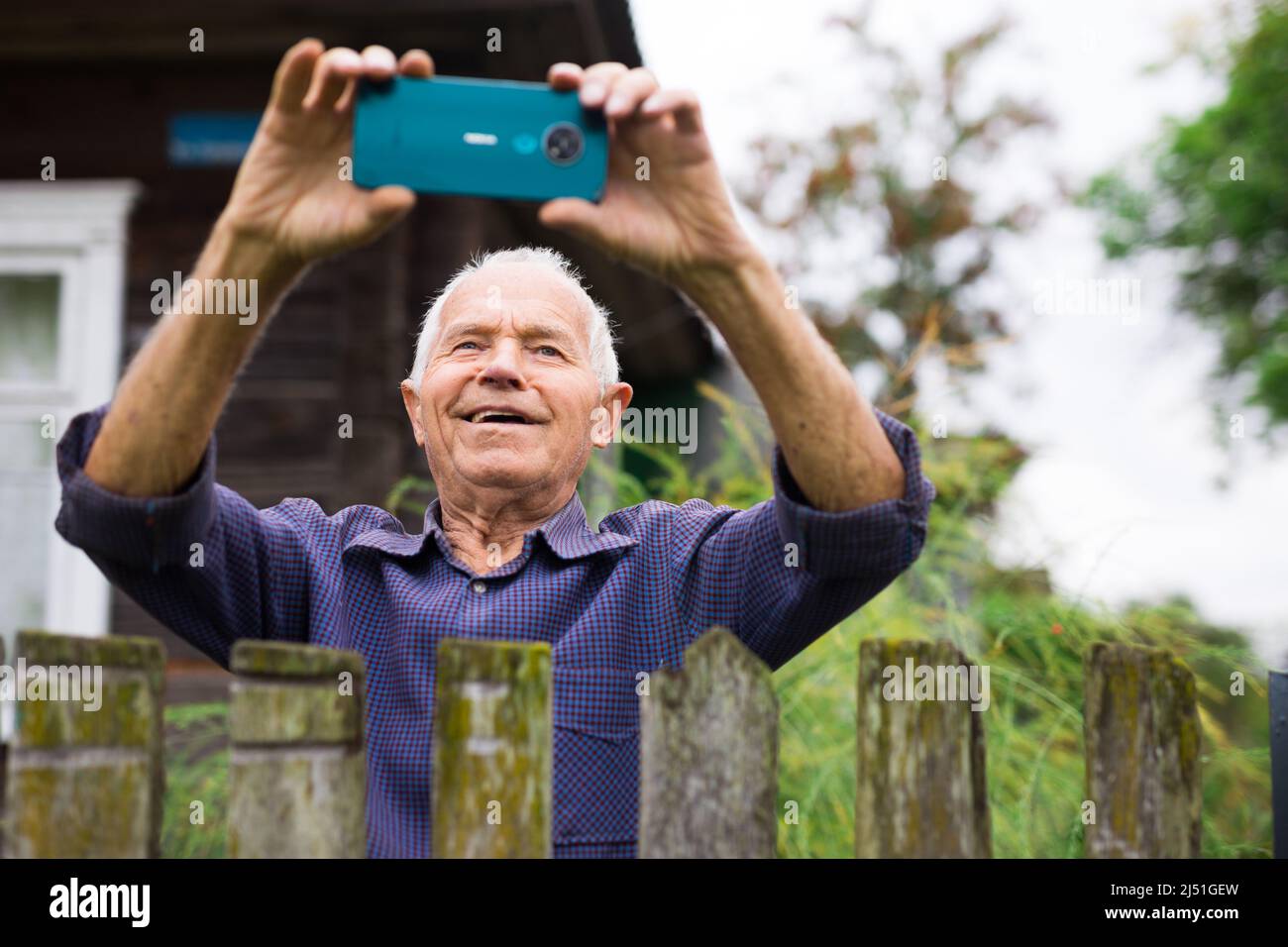 Old man with smartphone taking photographs outdoors Stock Photo - Alamy