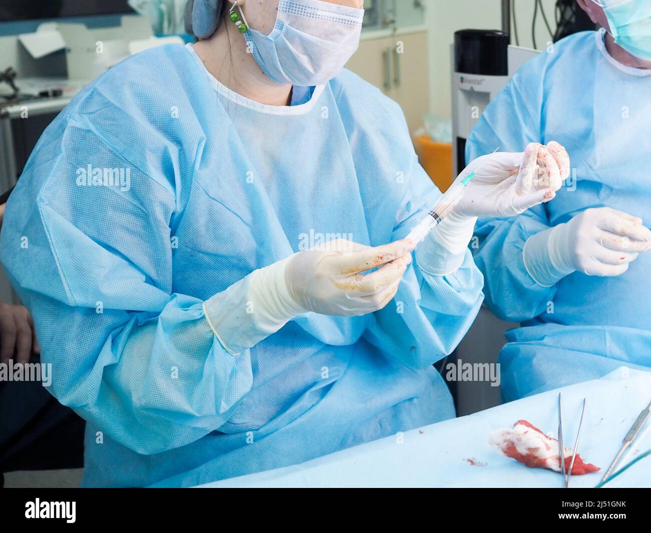 Syringe in the hands of a surgeon during a surgical operation in the ...