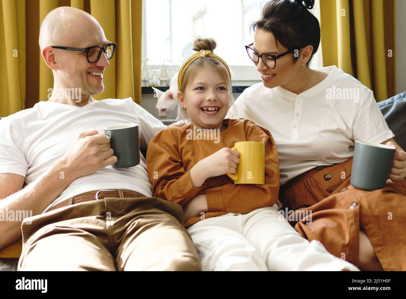 Happy family drinking hot tea in the living room of their cozy ...