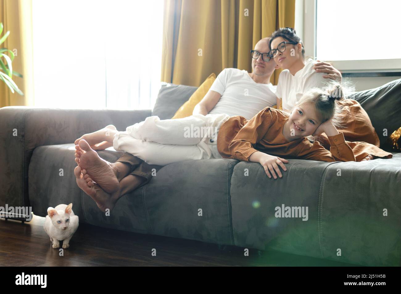 Happy family relaxing and watching TV show at home Stock Photo - Alamy