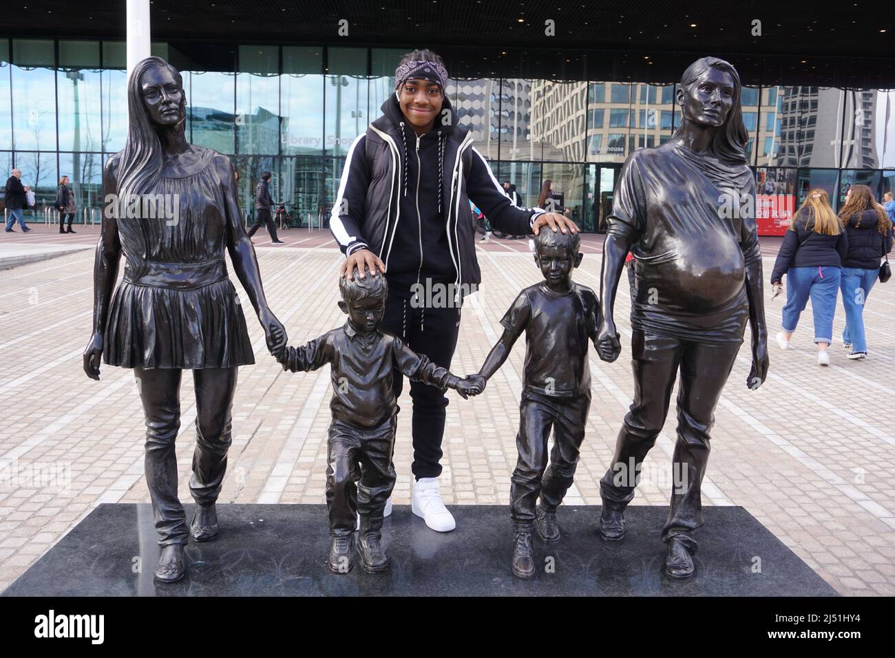 Young boy posing with Public sculpture by Gillian Wearing of two ...