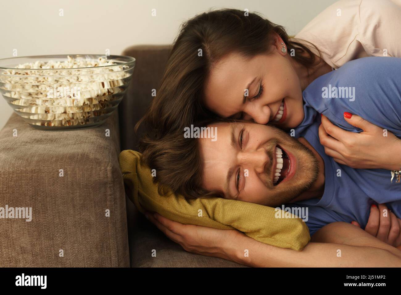 Young and happy couple watching comedy TV show at home Stock Photo - Alamy