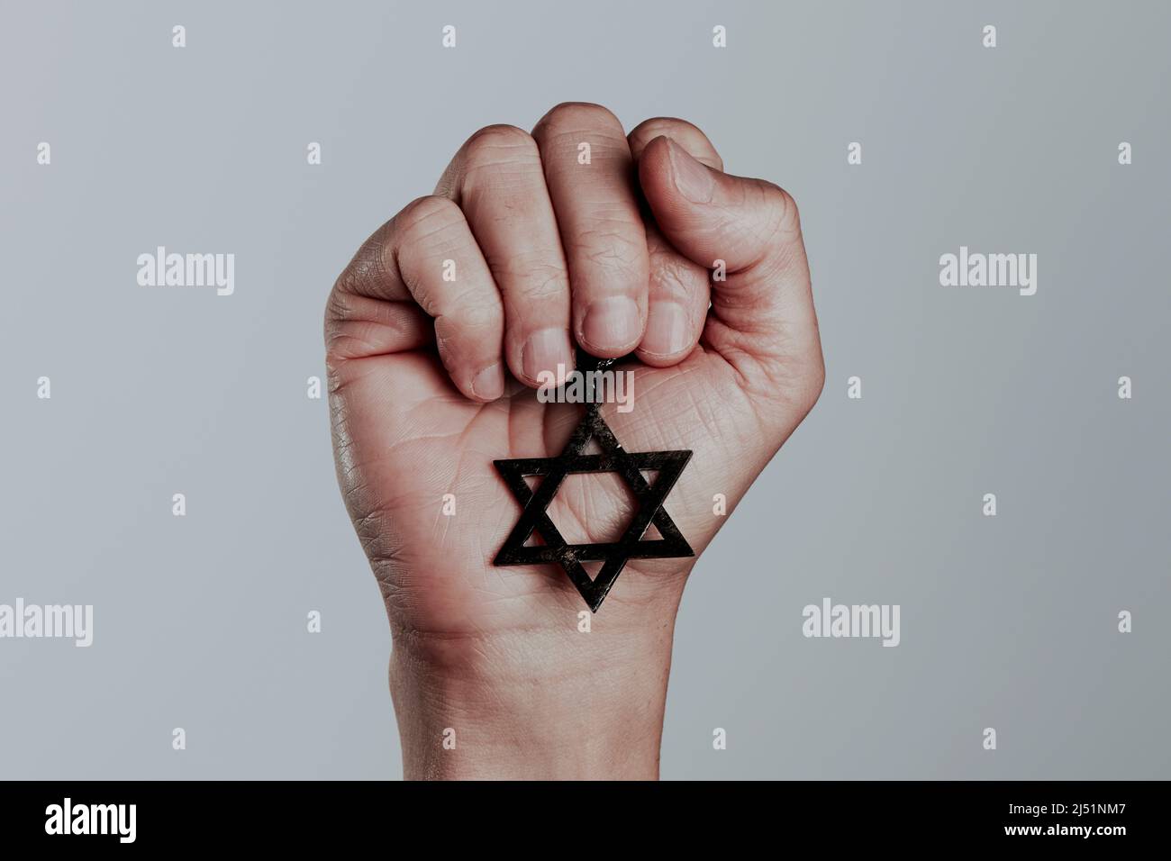 closeup of the hand of a man with an old and rusty pendant in the shape ...