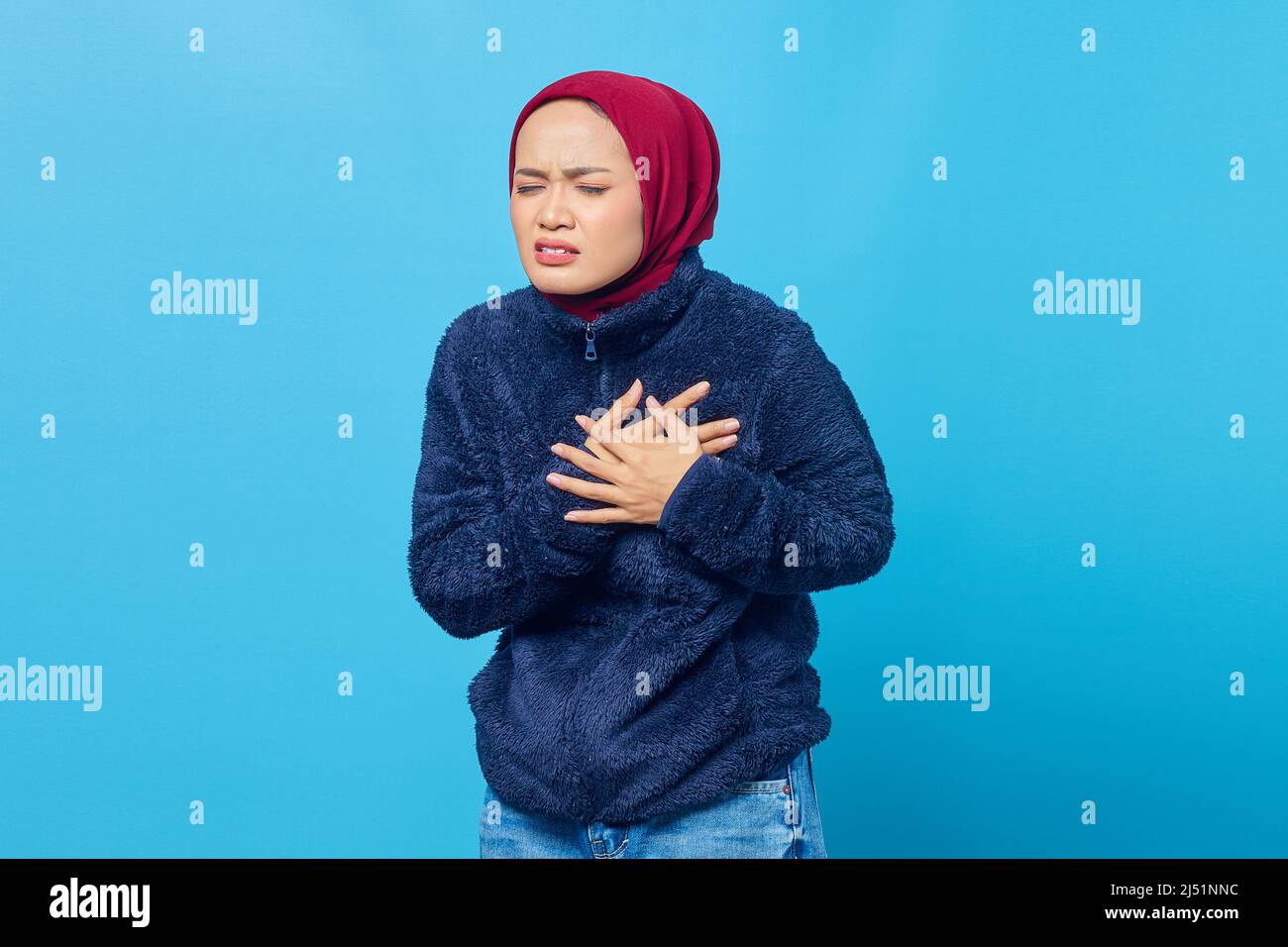 Portrait of young Asian woman feeling short of breath and keeping both ...