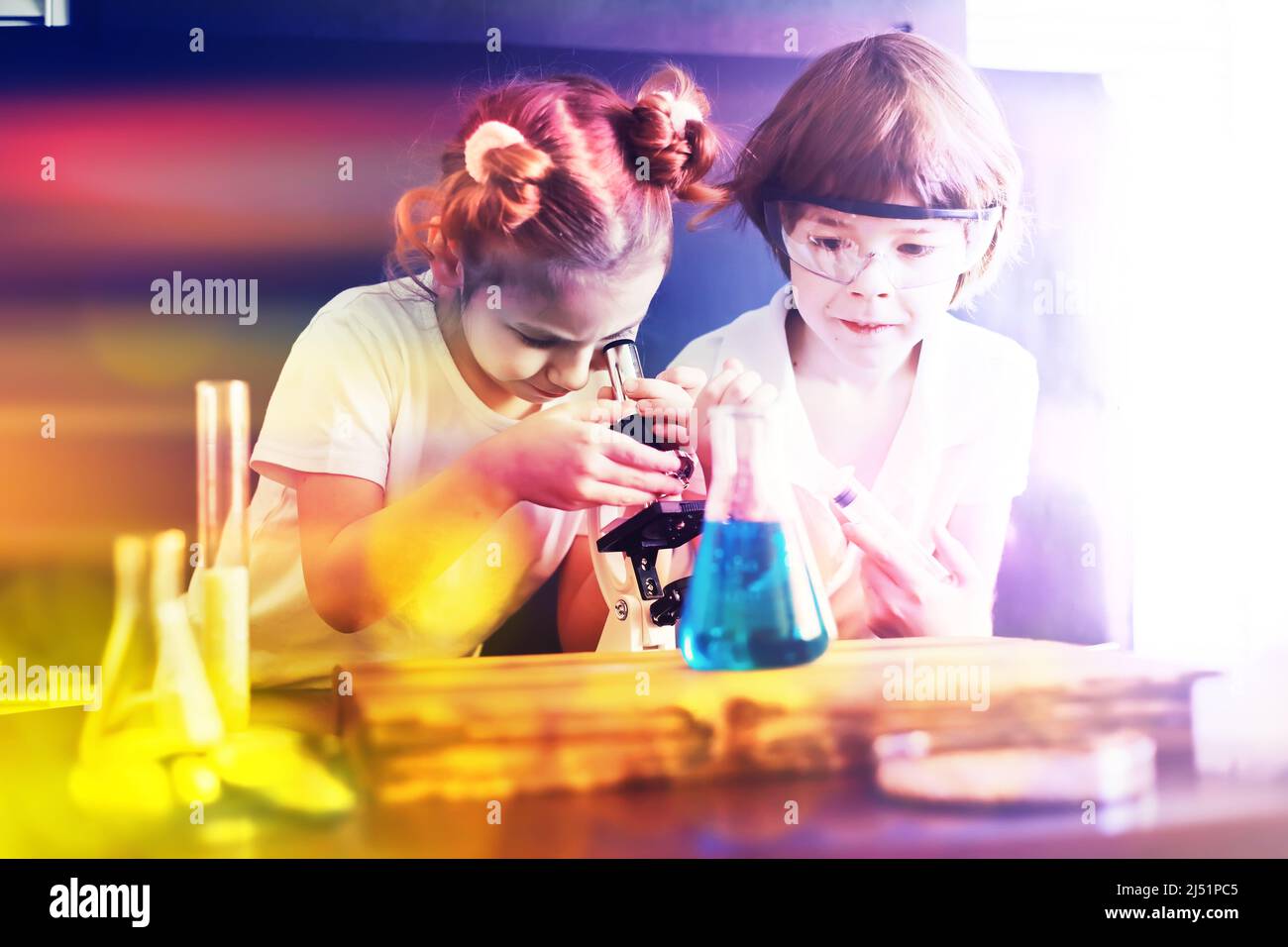 Children scientists. Schoolchildren in laboratory conduct experiments ...
