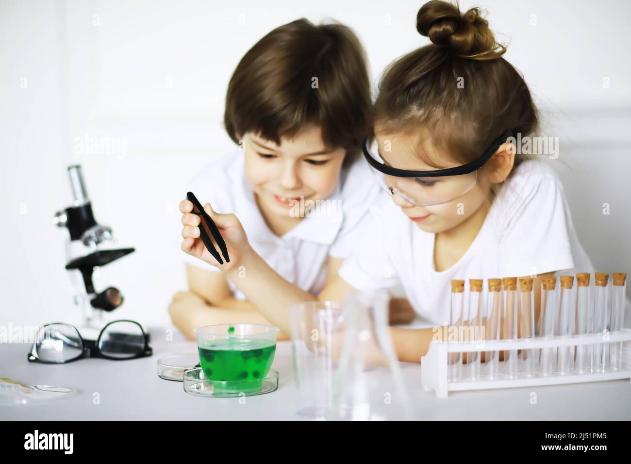 Two cute children at chemistry lesson making experiments isolated on ...