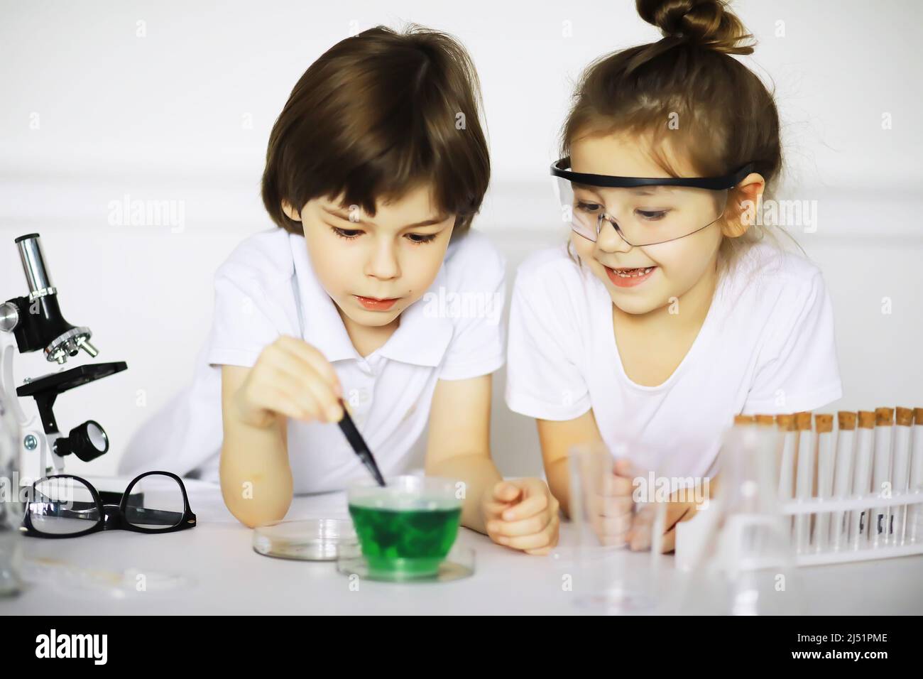 Two cute children at chemistry lesson making experiments isolated on ...