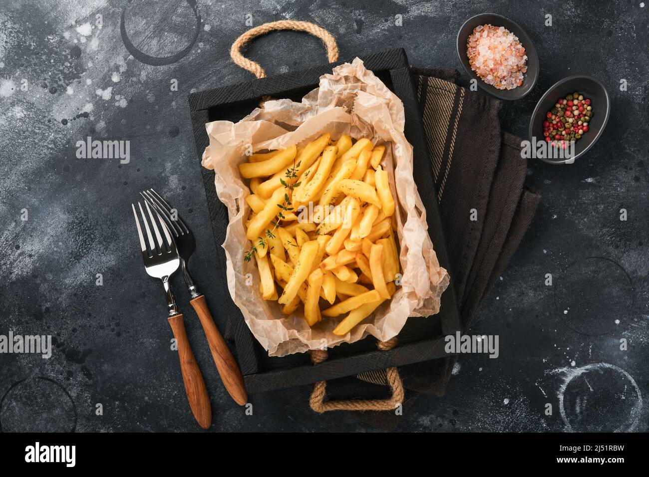 French fries. Tasty French fries server on parchment paper on wooden ...