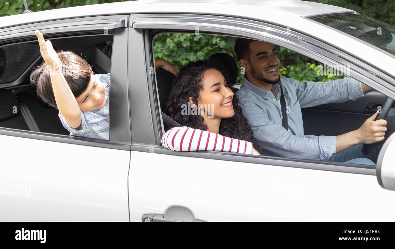 Happy millennial middle eastern male and female driving by car, little ...