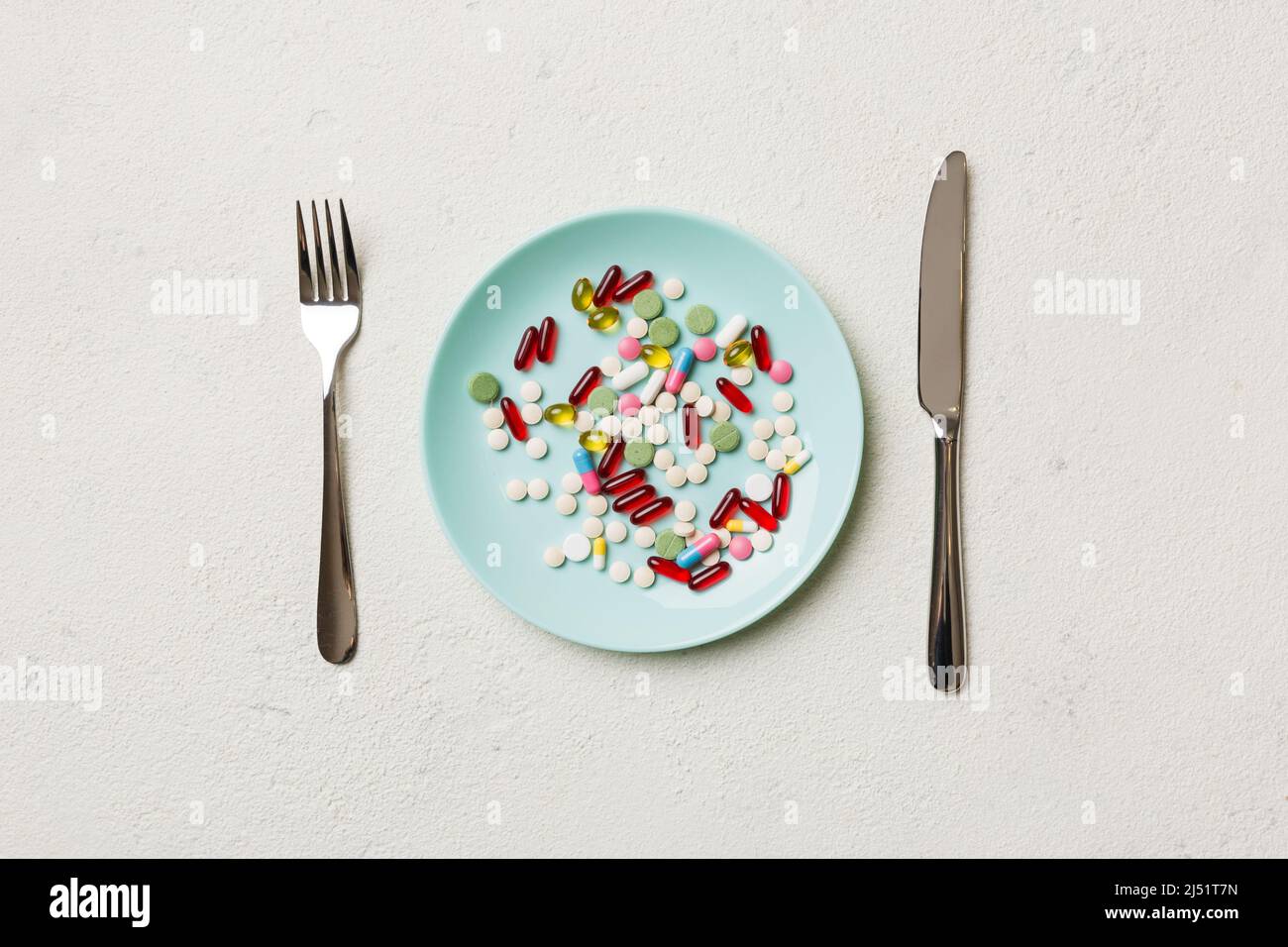 Many different weight loss pills and supplements as food on round plate ...