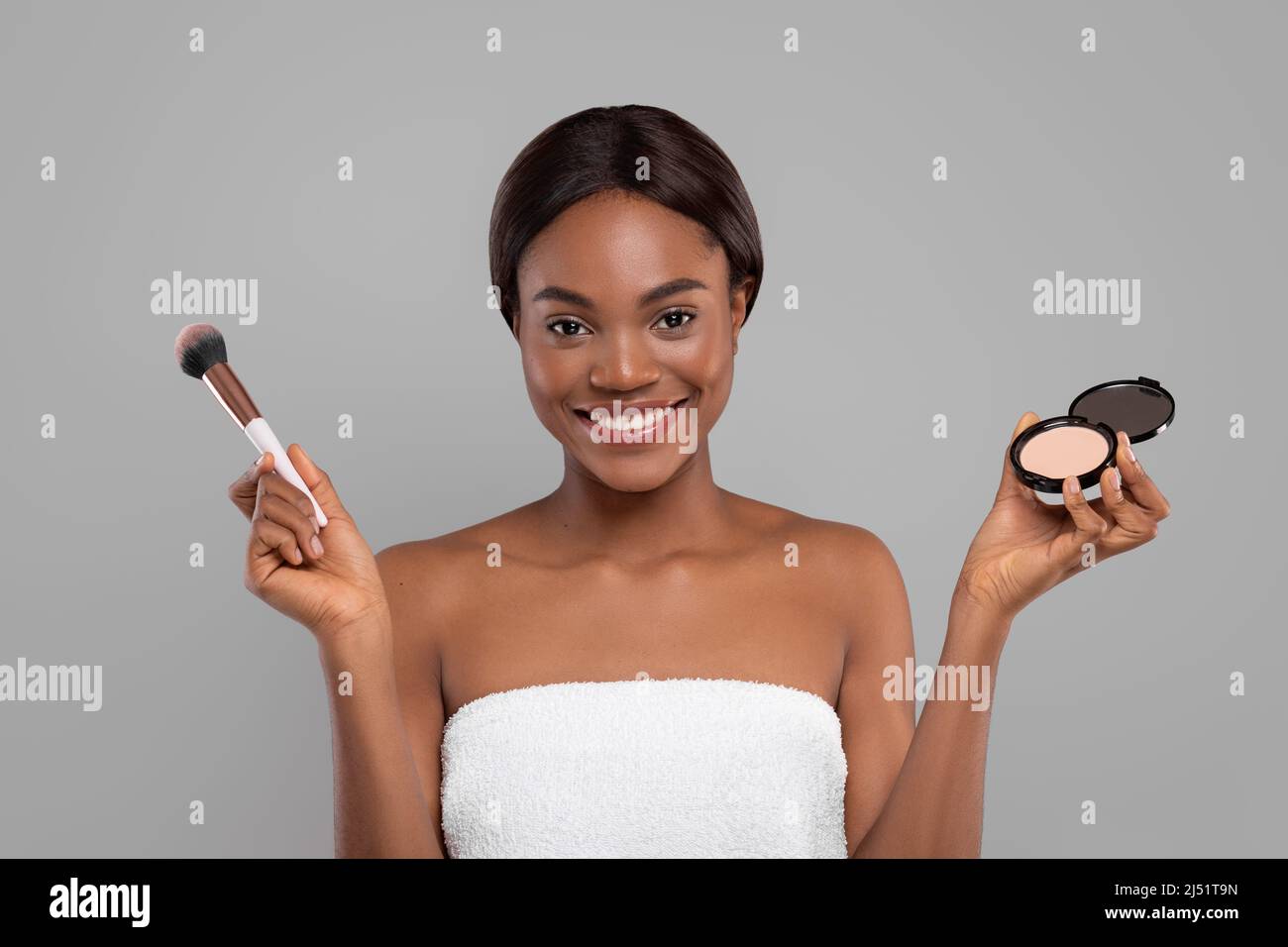 Happy pretty black lady with perfect skin do basic makeup with ...