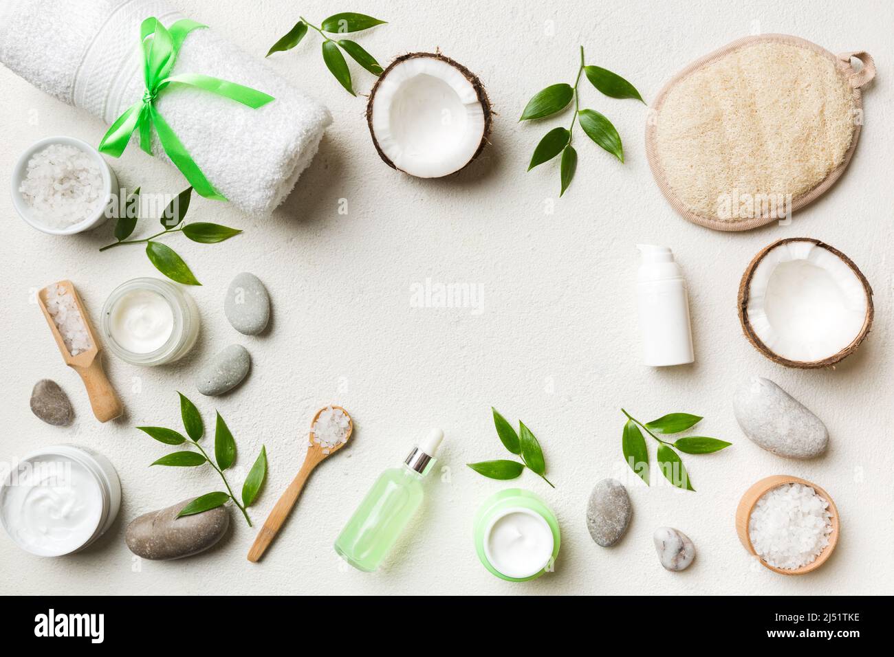 Coconut with jars of coconut oil and cosmetic cream on colored ...