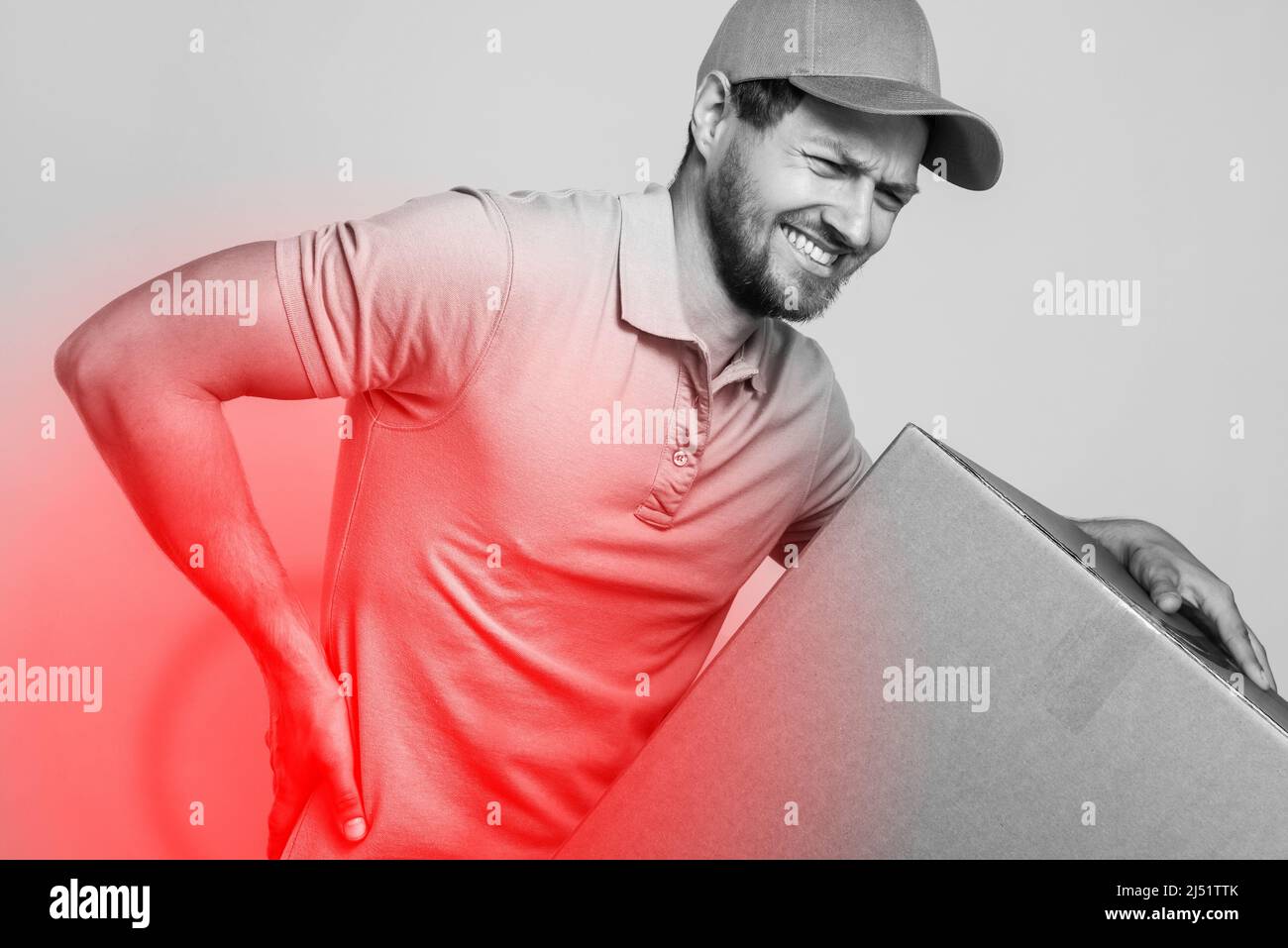 Delivery man suffering from a back pain while carrying heavy cardboard ...