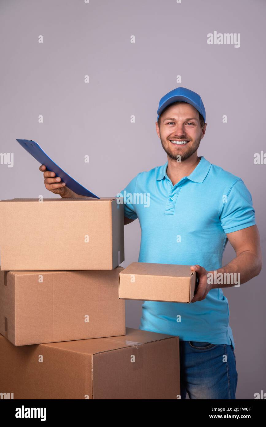 Happy delivery man during work with a packages in a cardboard boxes ...