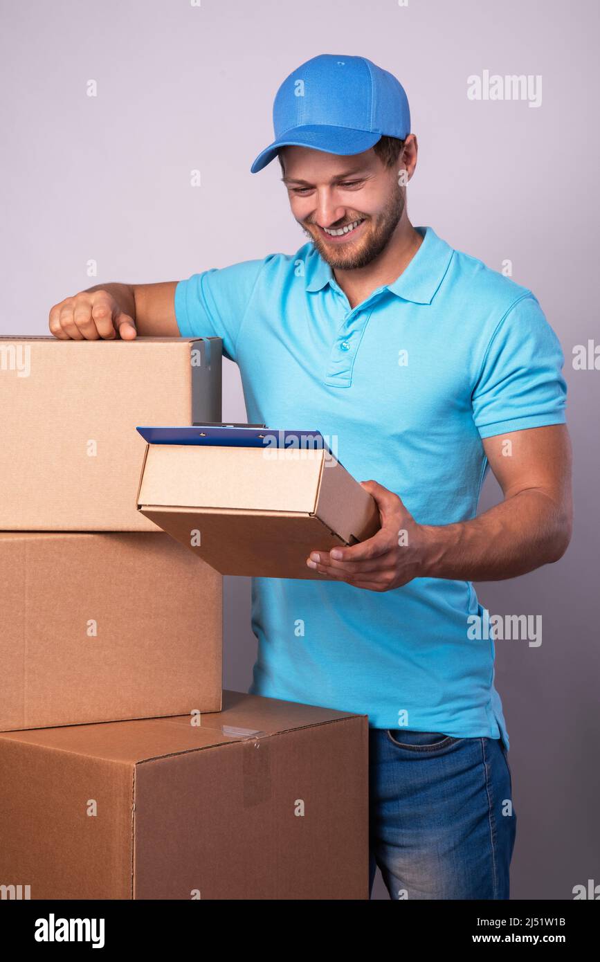 Happy delivery man during work with a packages in a cardboard boxes ...