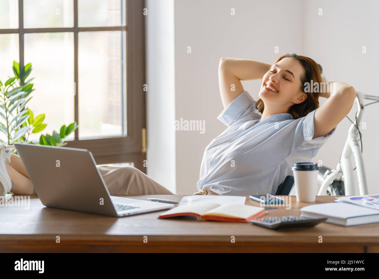 Happy woman ix relaxing working in the office Stock Photo - Alamy