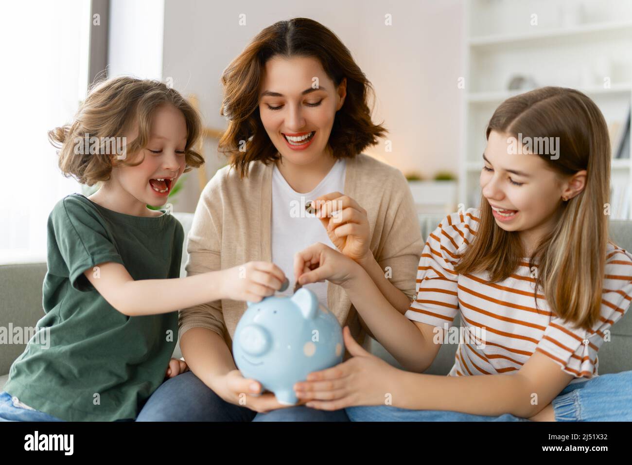 Woman and children with a piggy bank are calculating expenses, managing ...