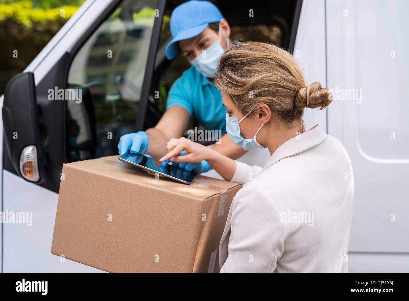 Prevention masks are new safety measures. Young woman receiving package ...
