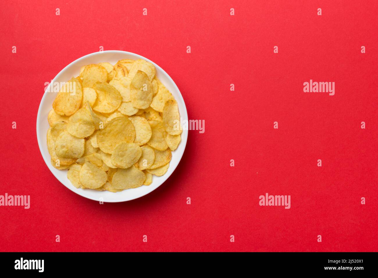 Potato chips on bowl isolated on colored background. Delicious crispy ...