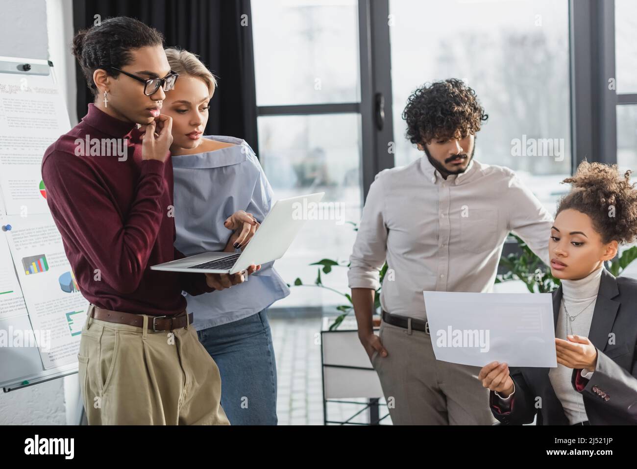 Multicultural business people working with paper and laptop in office ...