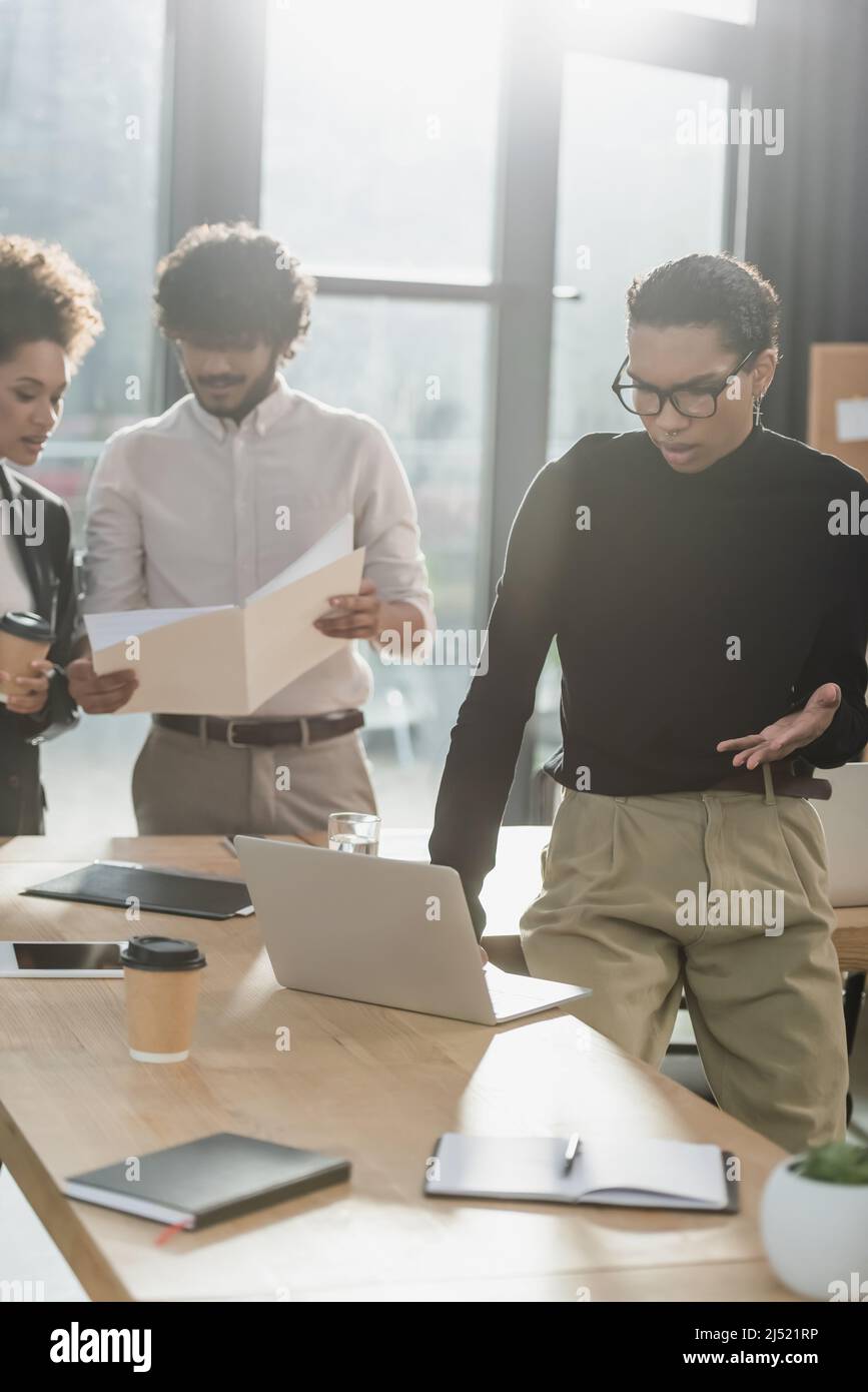 African american businessman having video call on laptop near blurred ...
