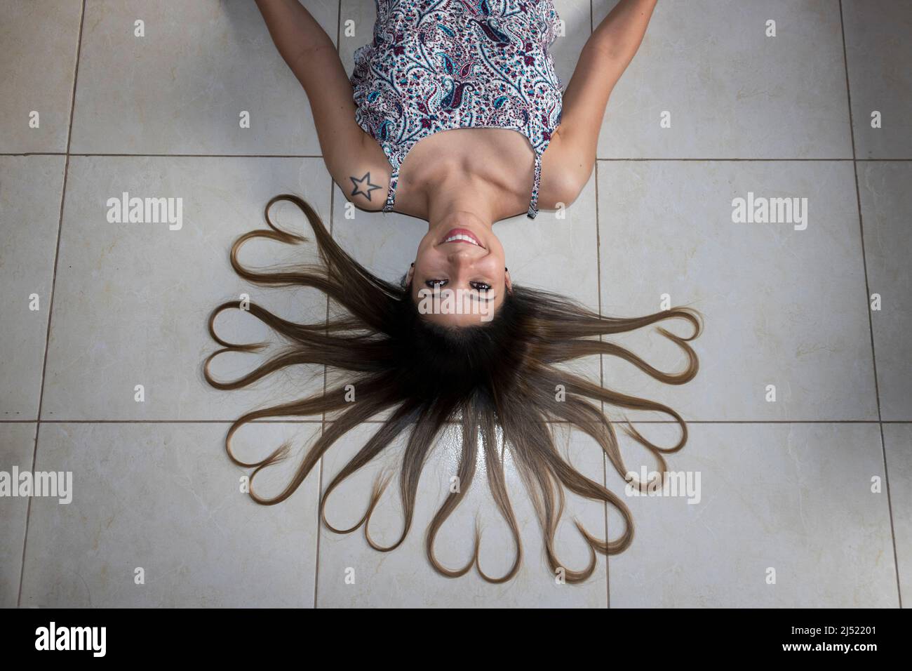 Girl lying on the floor with heart shaped hair Stock Photo - Alamy