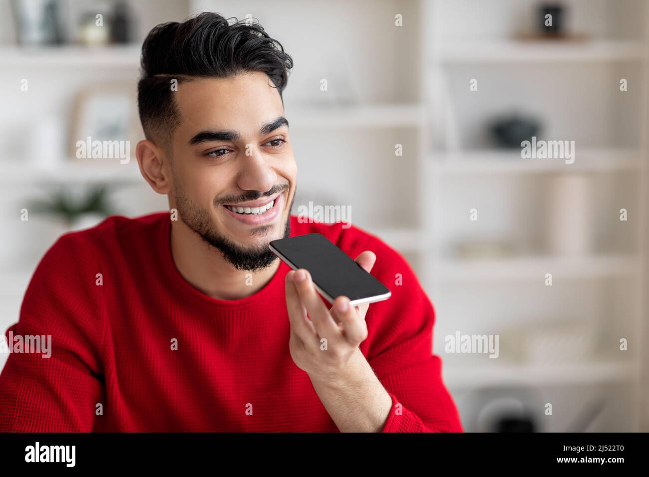 Glad Attractive Millennial Arab Guy With Beard In Red Clothes Speaks By