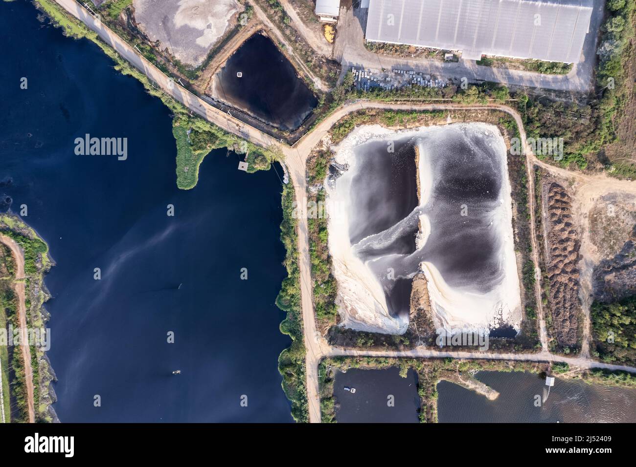 Aerial view of large wastewater treatment pond and plastic covered ...