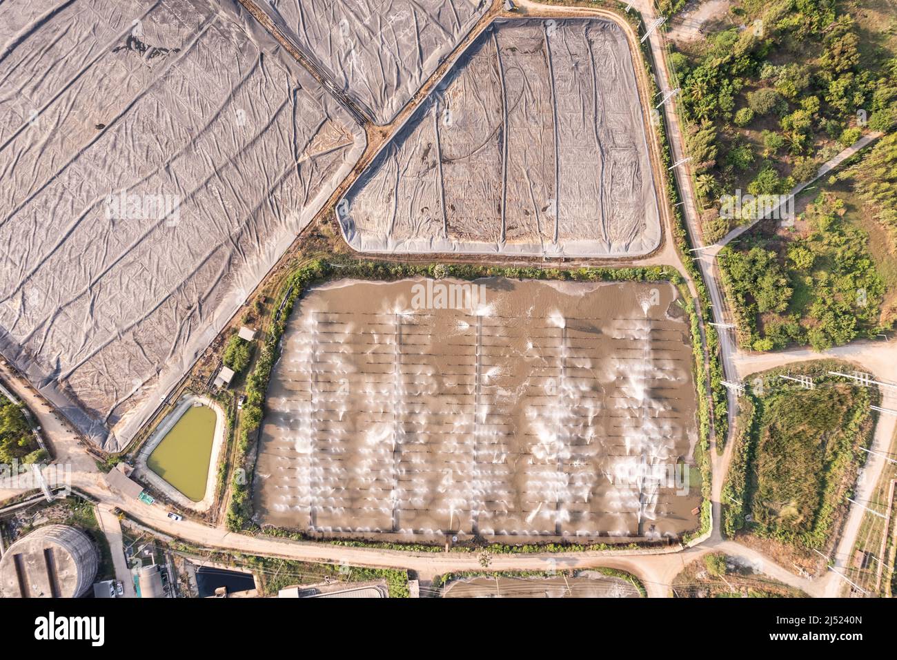 Aerial view of large wastewater treatment pond and plastic covered ...