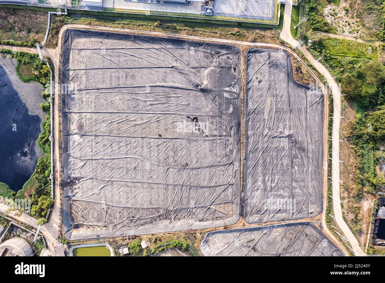 Aerial view of large wastewater treatment pond and plastic covered ...