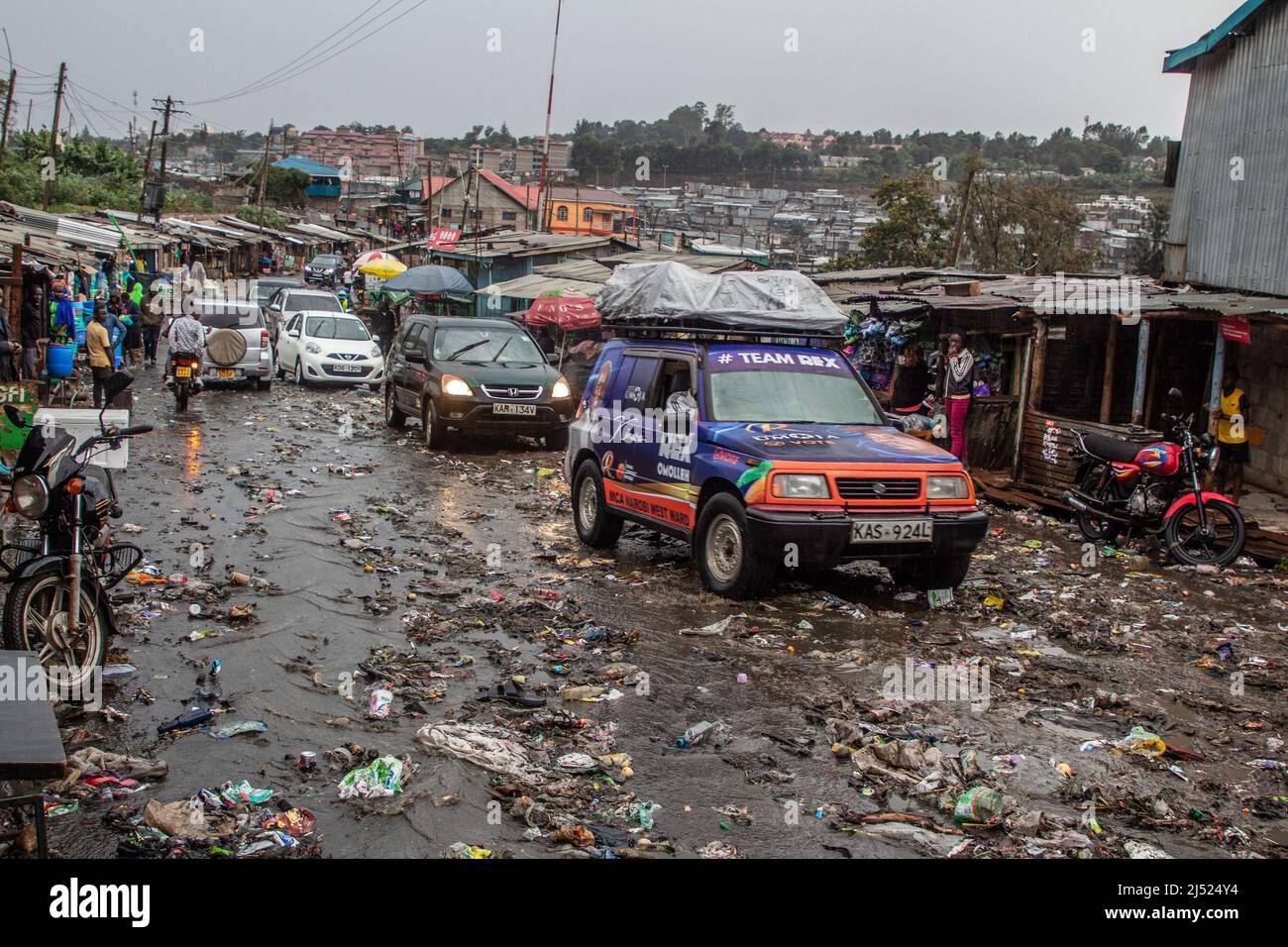 Cars are seen passing through a rabbish spread along a street road ...