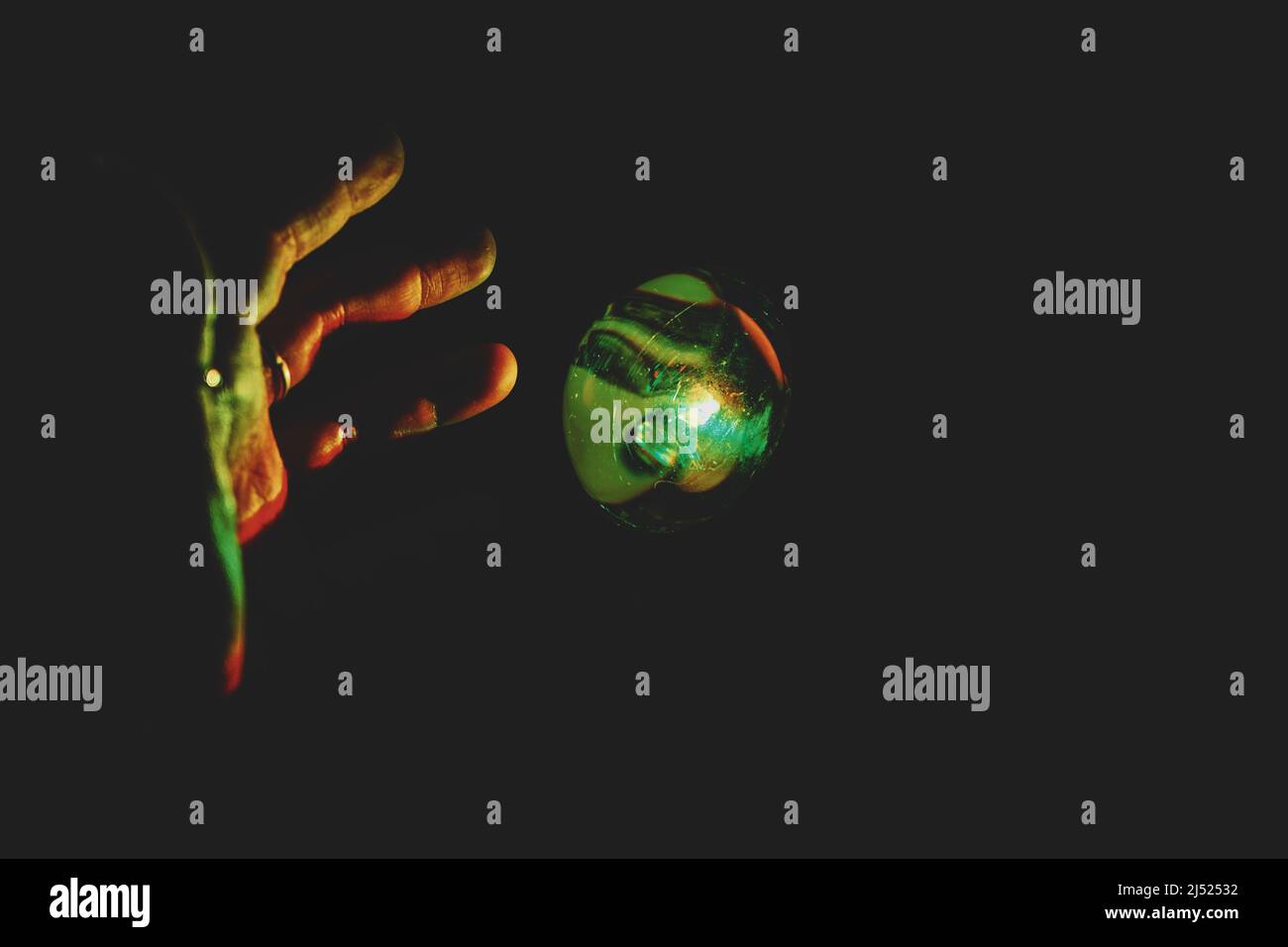 Hand trying to touch a magic colorful ball Stock Photo - Alamy