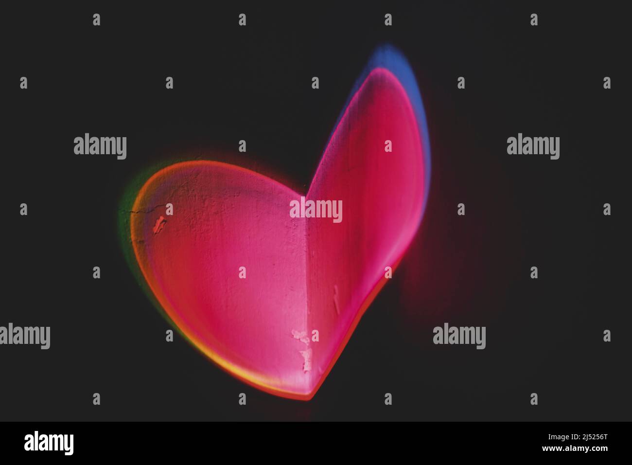 Colorful light heart shape projected in a wall Stock Photo - Alamy