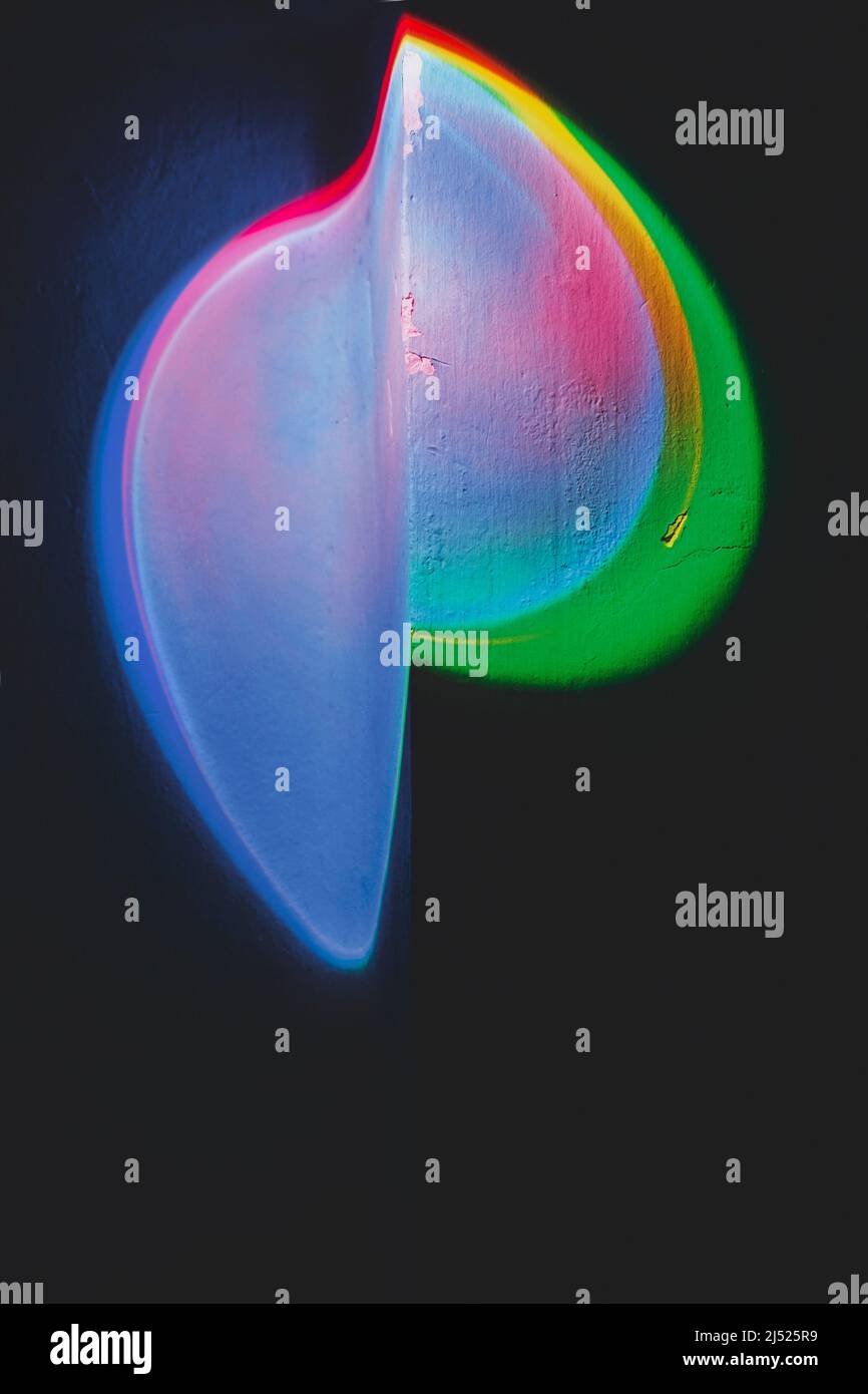 Abstract image of colorful shapes of light against black background ...