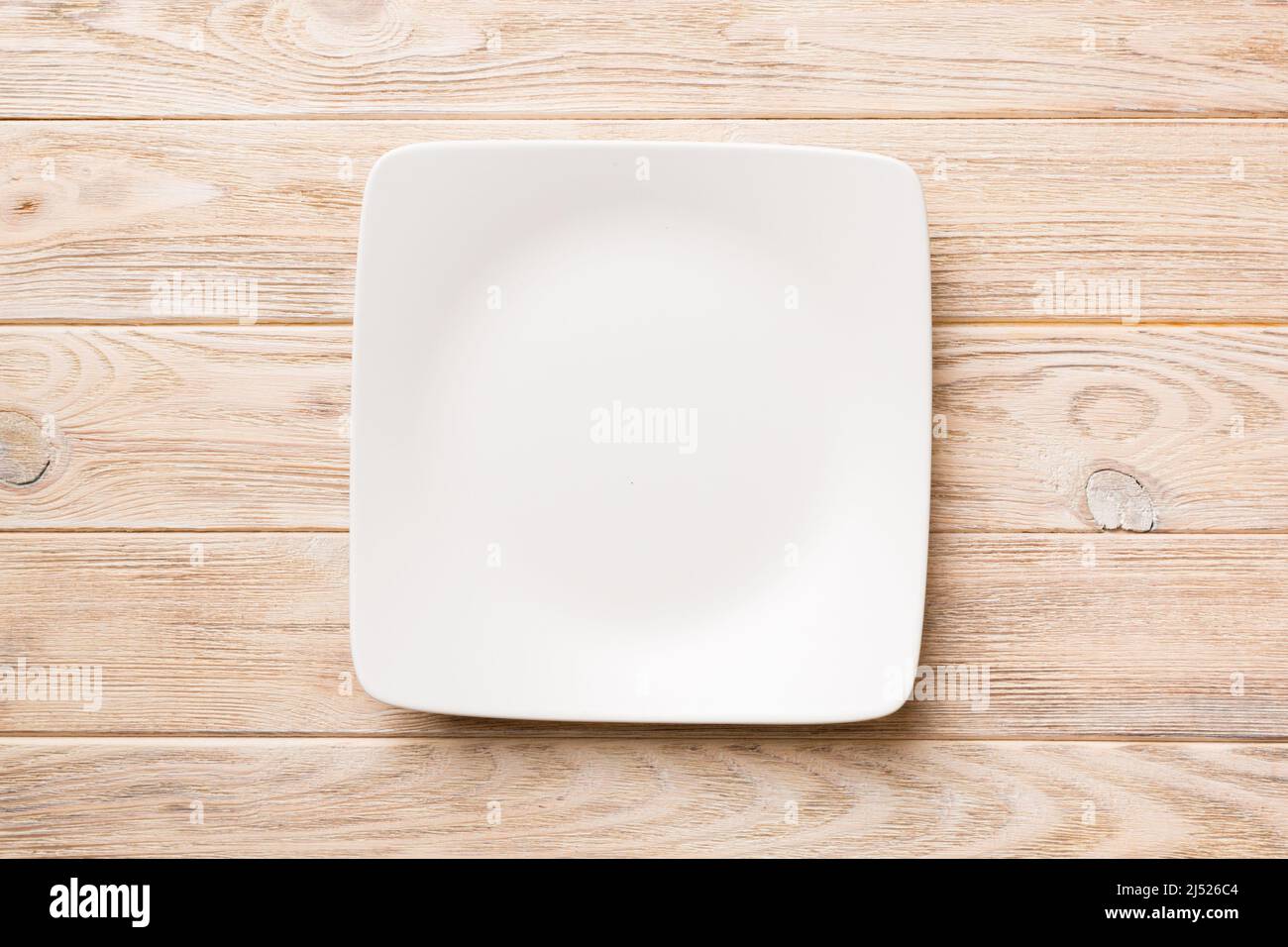 Top view of empty square plate on wooden background. Empty space for ...