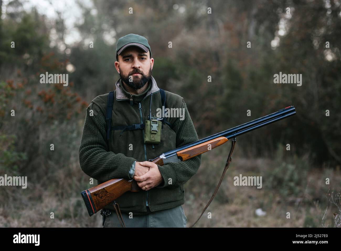 Confident man with rifle in woods during hunting Stock Photo - Alamy