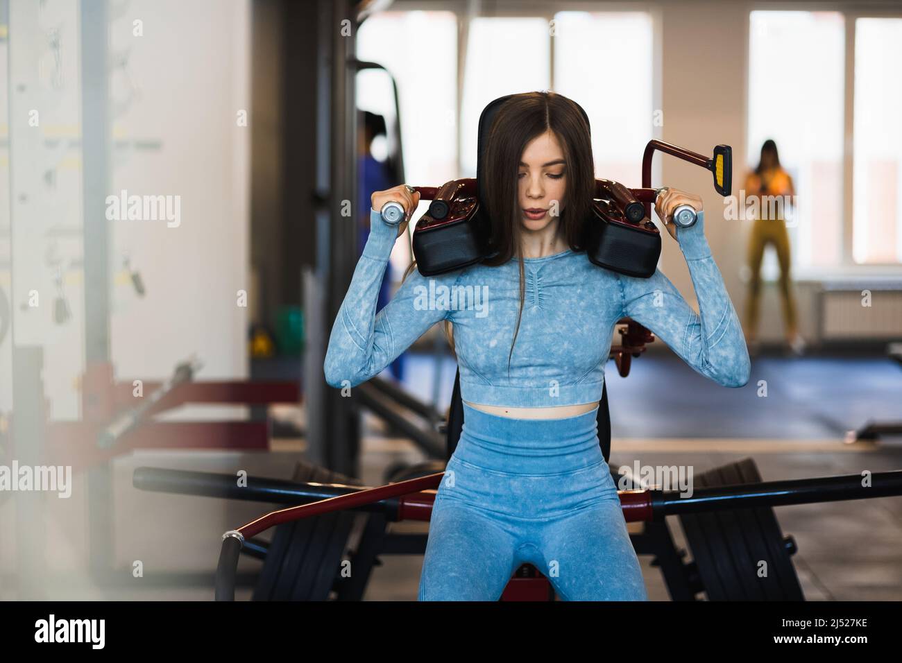 Athletic woman doing squatting on training machine. Legs muscle ...