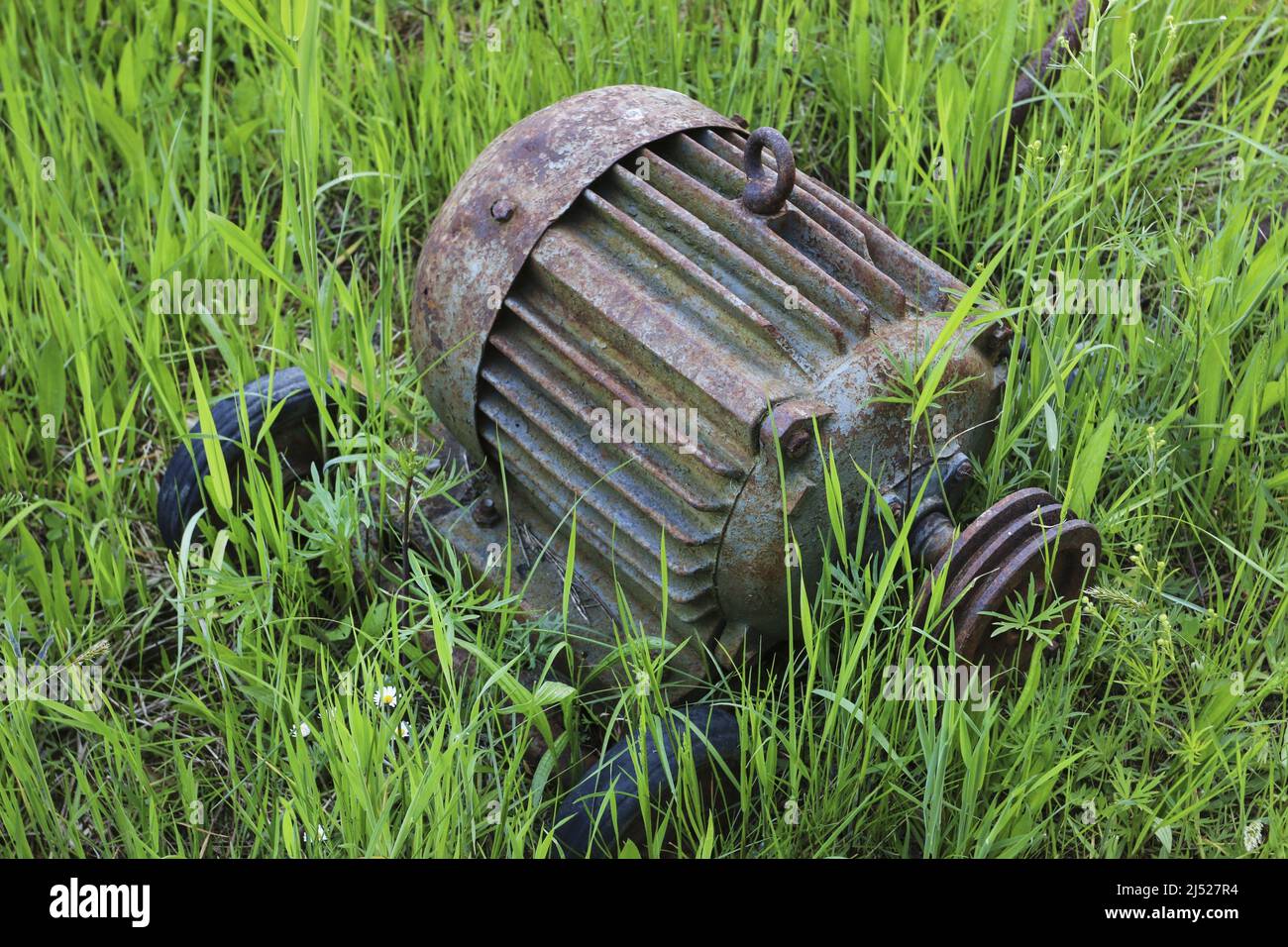 An antique electric motor lying on the grass. Vintage mashine Stock ...