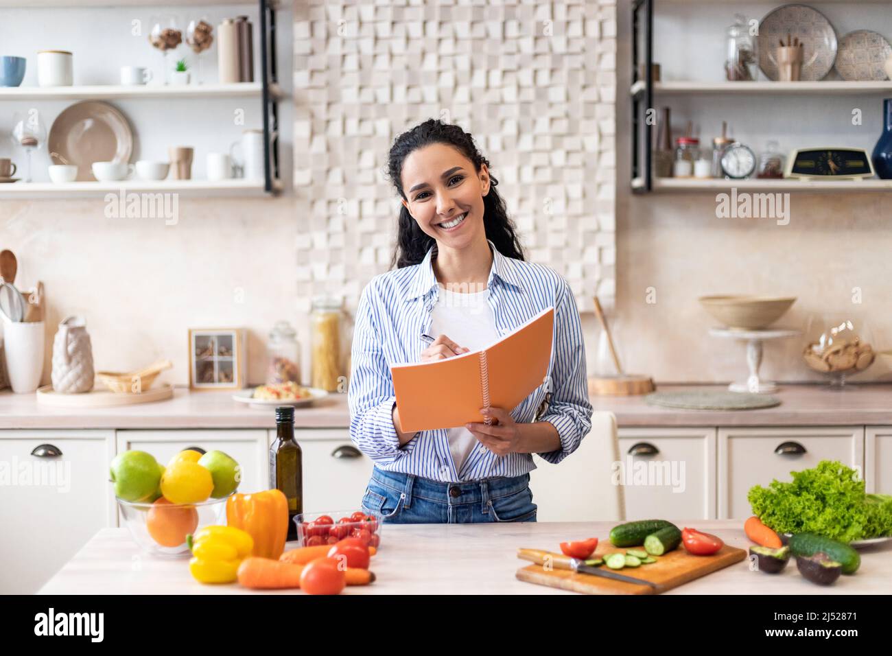 Healthy eating and diet concept. Excited woman making list of necessary ...