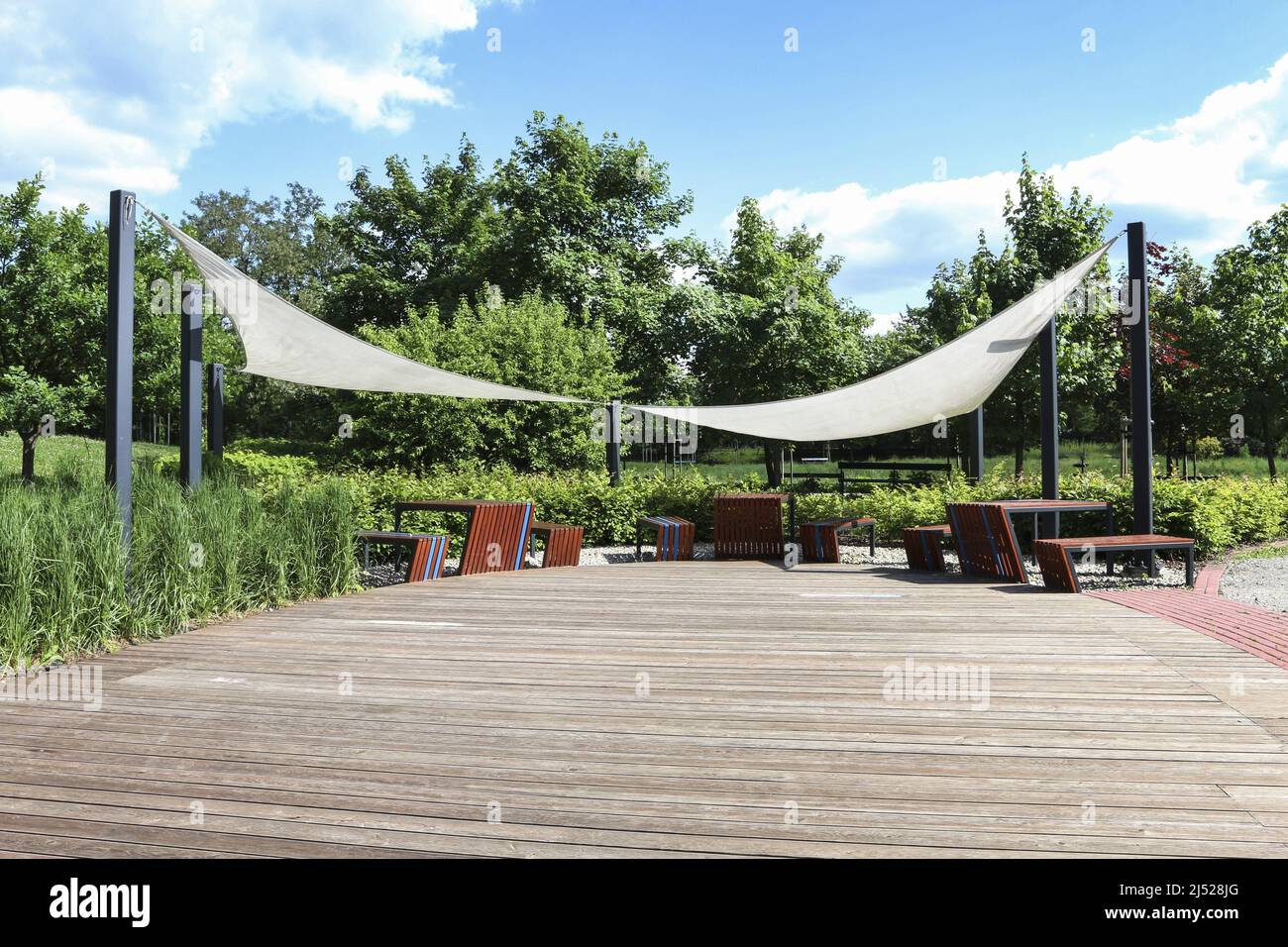 Wooden seats in the park, sheltered from the sun by a canopy. Relax ...
