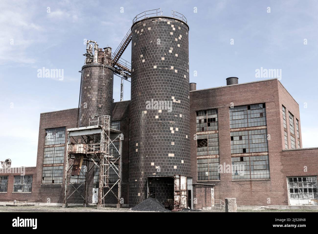 Abandoned coal power plant with broken windows, excess coal and worn ...