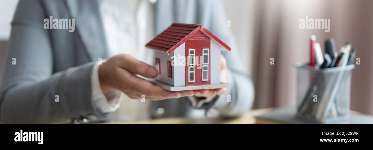 Insurance concept the property dealer presenting the new model of house ...