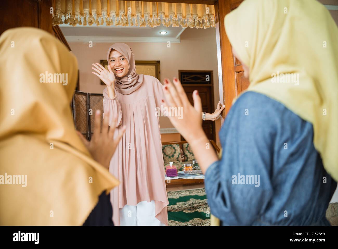 muslim woman welcoming guest's at home on eid mubarak Stock Photo - Alamy