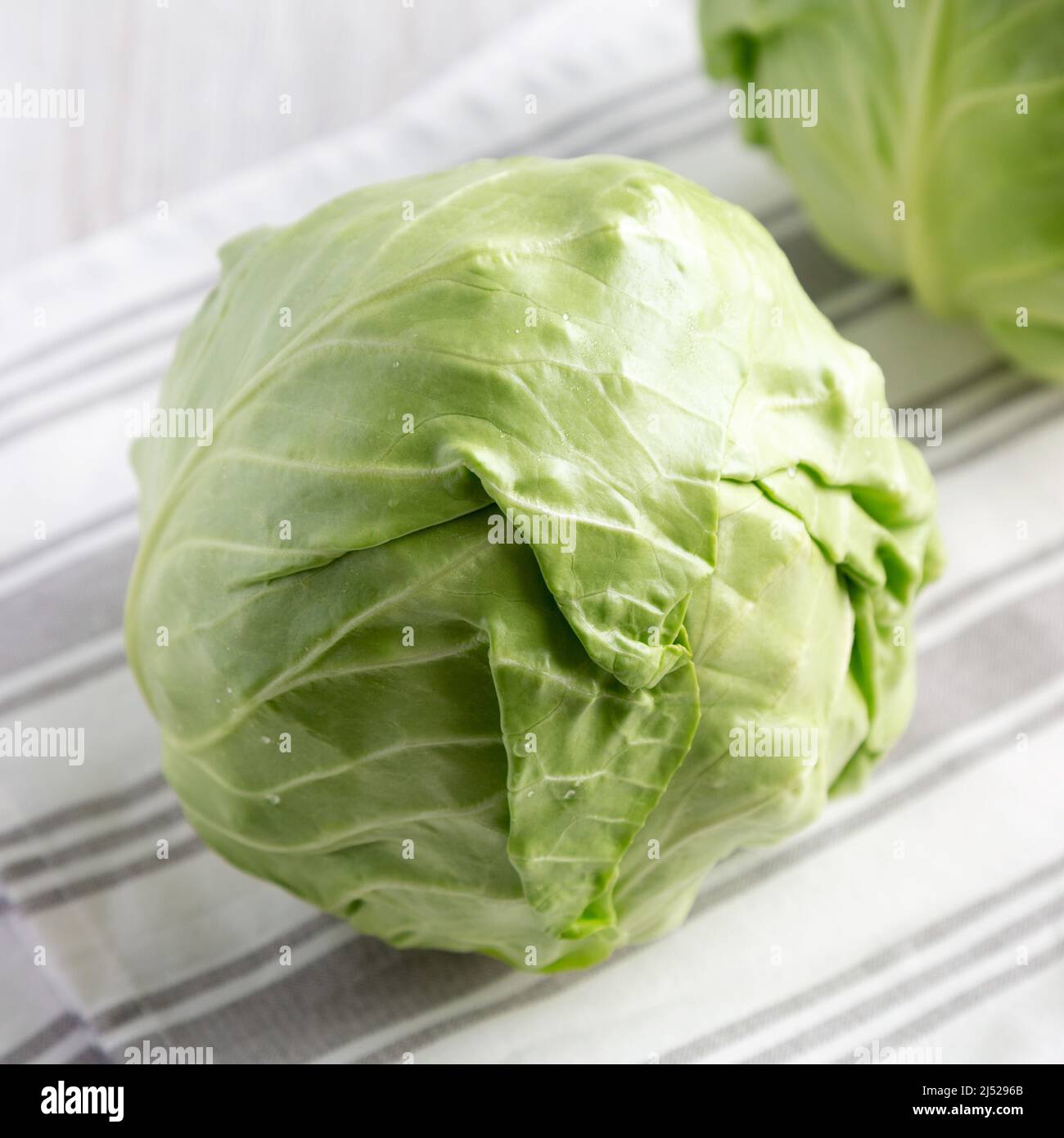 Raw Organic Cabbage on a white wooden background, side view Stock Photo ...