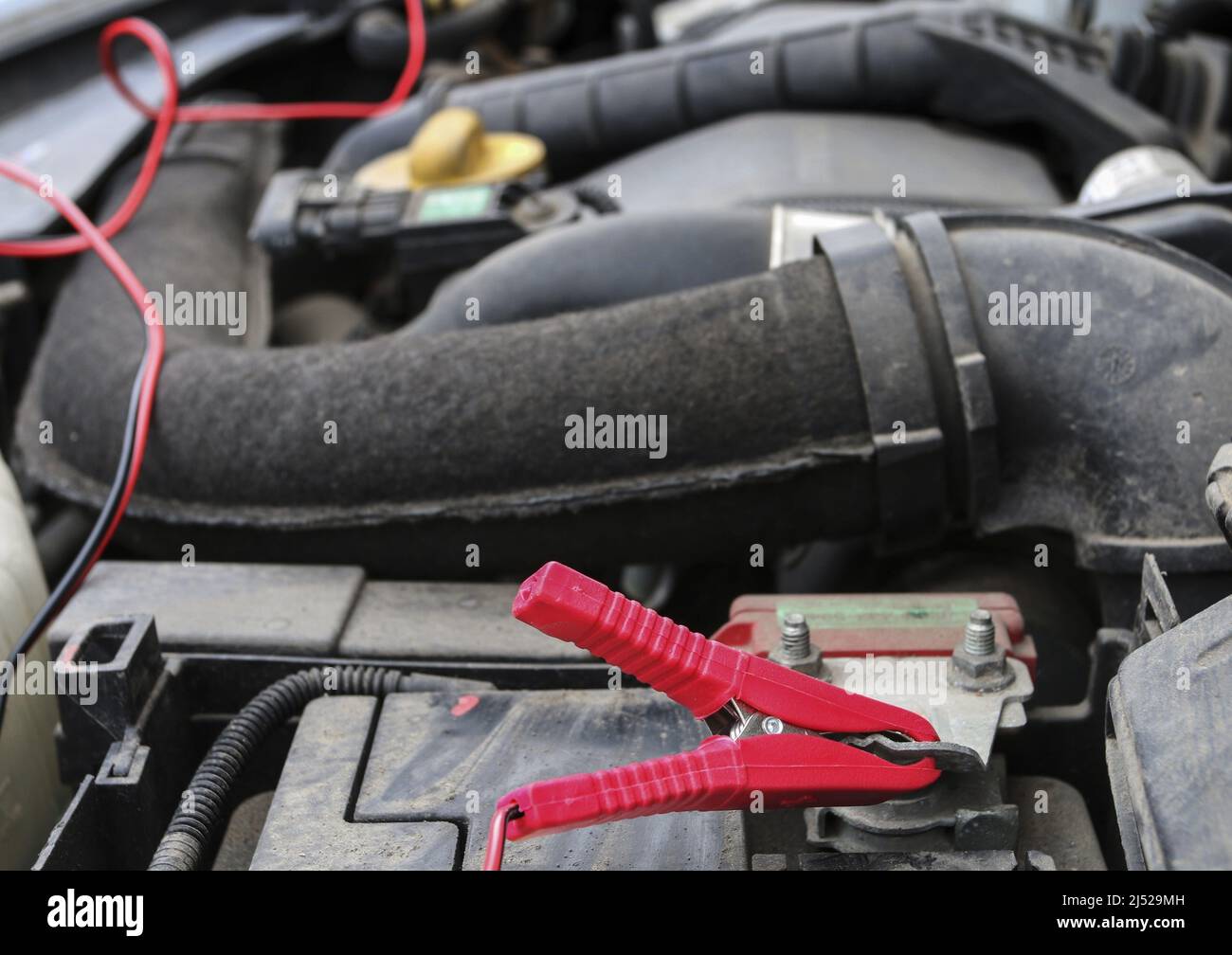 Jumper cable (booster cable) in car. Mechanic worker Stock Photo - Alamy