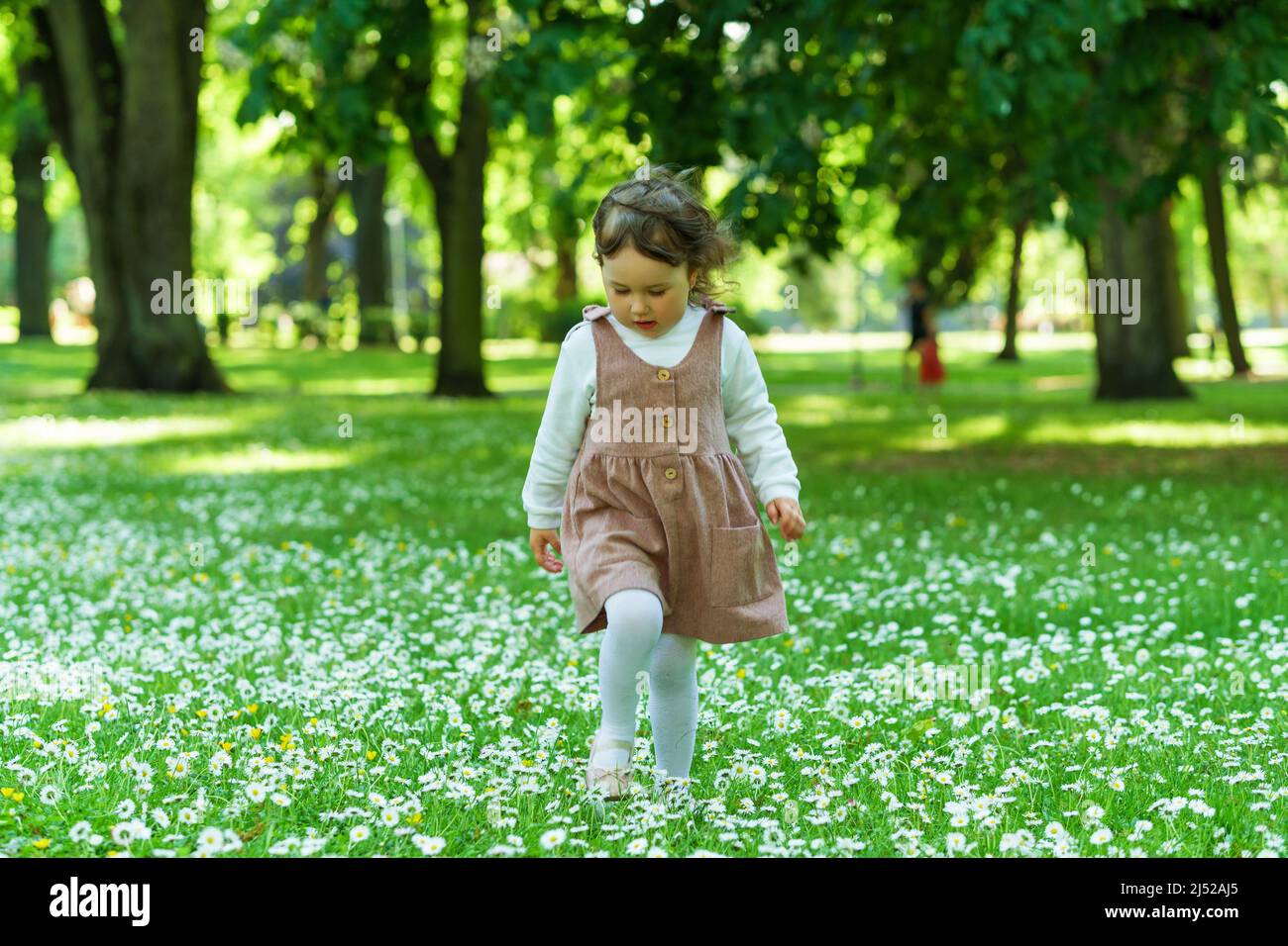 Childhood and carefreeness. Cute little girl walks in a city park Stock ...
